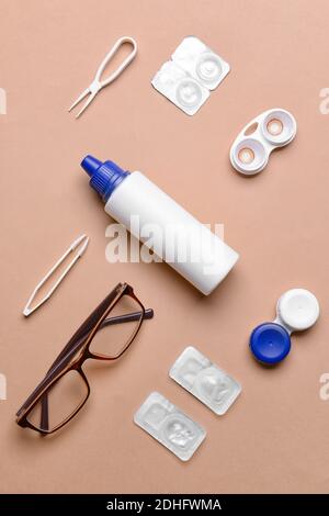 Containers with contact lenses, solutions and tweezers on color ...