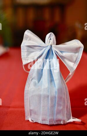 Two surgical masks formed into the crafty shape of an angel with wings ...