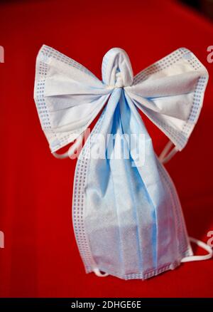 Two surgical masks formed into the crafty shape of an angel with wings ...