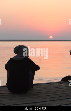 A boy enjoying the view. Sunset at ferry ghat Majuli Stock Photo - Alamy