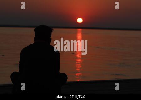 A boy enjoying the view. Sunset at ferry ghat Majuli Stock Photo - Alamy