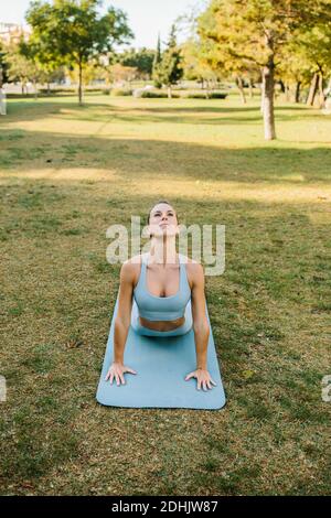 Young woman practicing high cobra asana in yoga studio. Bhujangasana ...