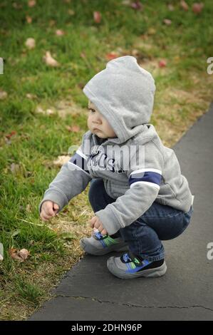Toddler child outdoors. One year old baby boy wearing straw hat with ...