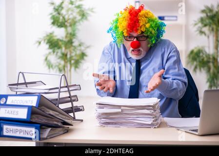 Aged businessman clown working in the office Stock Photo - Alamy