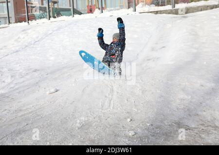 happy boy sliding on sled down snow hill in winter Stock Photo - Alamy