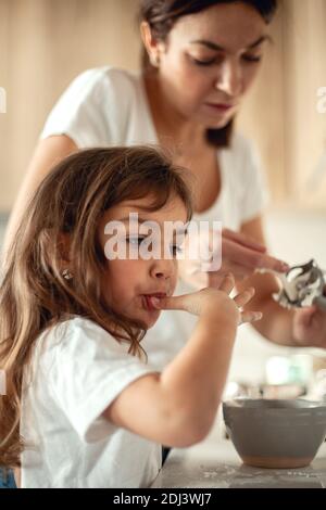 Mom helps her daughter decorate the cookies in the form of snowflake ...