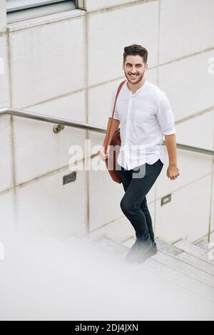 Cheerful young businessman walking on the street Stock Photo - Alamy