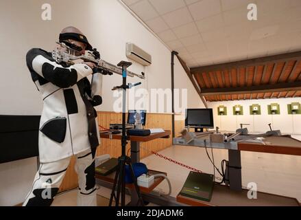 Professional shooter with sporting air rifle and technical gear, during ...