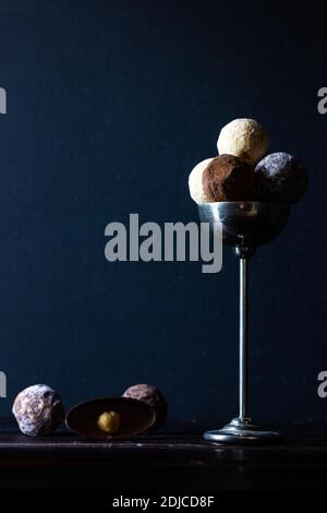 Chocolate truffles in small wooden dish sprinkled with cocoa powder ...