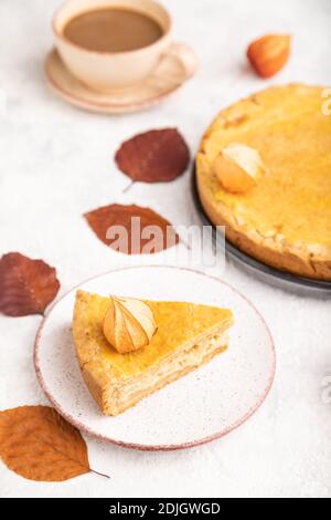 Autumn onion pie decorated with leaves and cup of coffee on gray ...