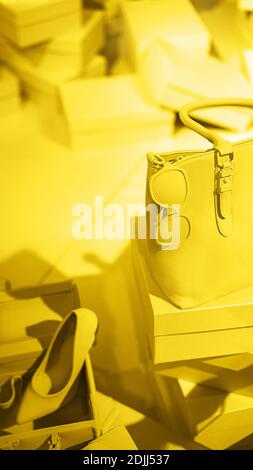 Bright illuminating yellow bag and glasses on gray color background ...
