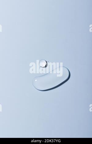 A top vie closeup of multiple waterdrops on a light pink background ...