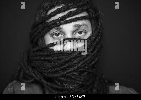 Man with dreadlocks covering face Stock Photo - Alamy