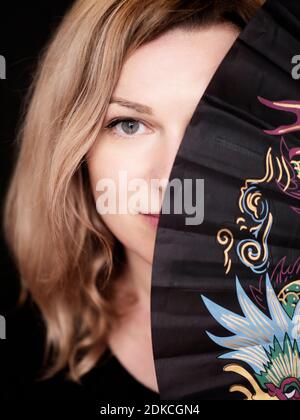 Beautiful girl partially hidden behind foliage Stock Photo - Alamy
