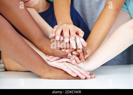 four children hold up their hands which are covered in paint from ...