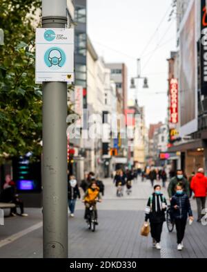 People wear masks out of concern for the coronavirus as they walk past ...