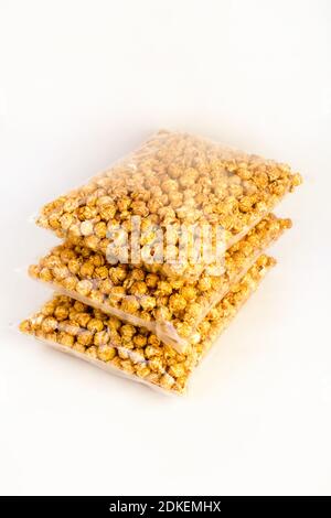 Caramel yellow popcorn in a package on a white background close up ...