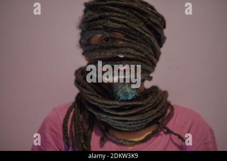 Man with dreadlocks covering face Stock Photo - Alamy