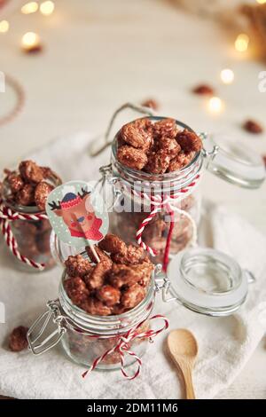 A vertical shot of delicious Christmas roasted almonds in a jar on a ...