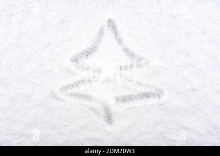 Simple textured Christmas tree drawn in fresh powder snow in bright ...