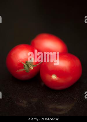 Three Ripe Roma Tomatoes, Fresh Basil and Eggplant from an Organic Garden on Off White ...