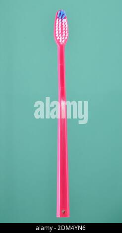 Pink toothbrush on mint color pastel background Stock Photo - Alamy