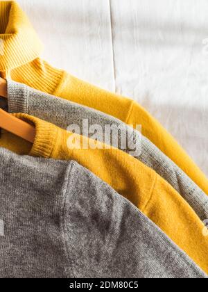 Yellow illuminated color winter sweaters on hangers Stock Photo - Alamy