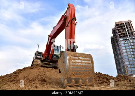 Excavator working at largest construction site. Backhoe on earthworks ...