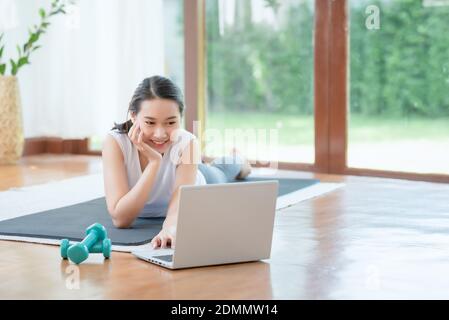 Beautiful asian woman staying fit by exercising at home for healthy ...