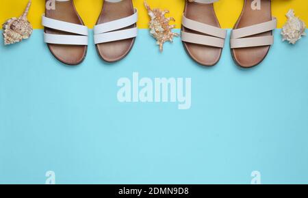 Fashionable leather women's sandals, seashells, sunblock on colored ...