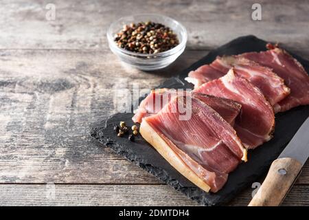 Smoked pork bacon slices on a wooden cutting board. wooden background ...