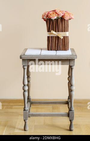 Floral arrangement with roses and cinnamon sticks stands on the table ...