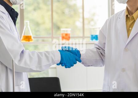 scientists shaking hands in laboratory Stock Photo - Alamy