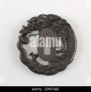 A round oval Iron Tsuba, a sword guard and part of a sword mounting. It ...