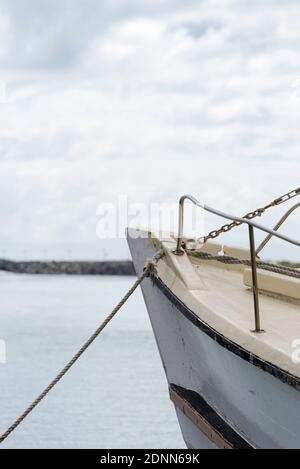 The bow or foredeck area and a mooring rope of an older timber fishing ...