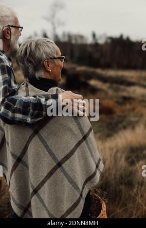 Positive couple standing together in fruit and vegetable section of ...