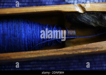 Vintage weaving loom shuttle with blue thread on denim Stock Photo - Alamy