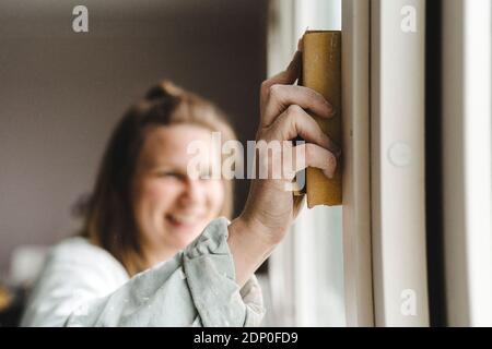 Womans hand sanding window frame Stock Photo - Alamy