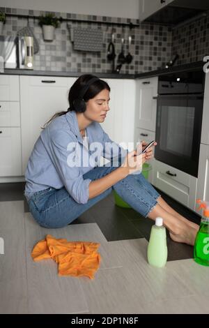 woman using smartphone while cleaning the kitchen Stock Photo - Alamy
