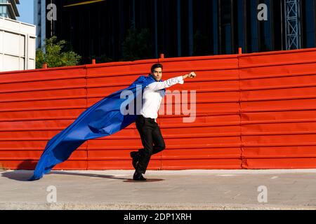 Businessman wearing superhero cape running on pavement Stock Photo - Alamy