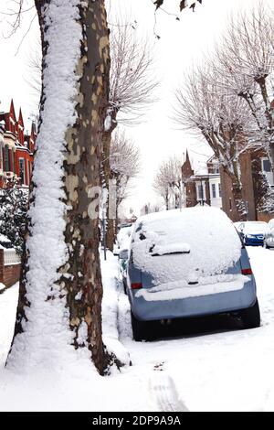 Street winter cityscape with snow terraced houses and frozen cars after ...