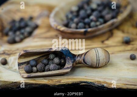 some allspice balls on olive wood Stock Photo - Alamy