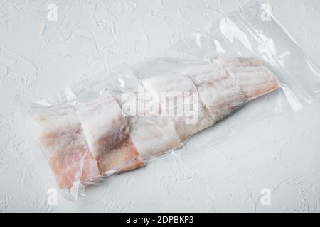 Raw haddock fish skinless plastic vacuum packaged, on black wooden ...