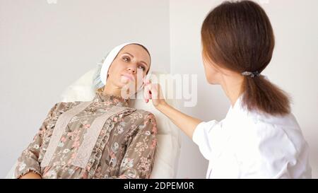 A woman in a white coat talks on a phone Stock Photo - Alamy