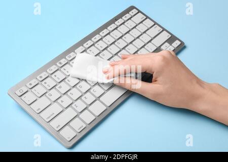 Woman cleaning computer keyboard on color background Stock Photo - Alamy