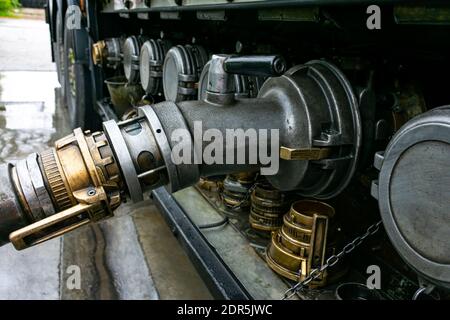 Fuel tanker unloading at a service station, with two hoses connected ...