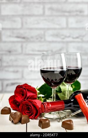 Bottle of wine, gift, glasses and hearts on green background. Valentine ...