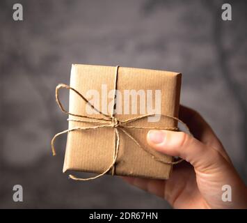 Wrapped christmas or other holiday handmade present in craft paper with ...