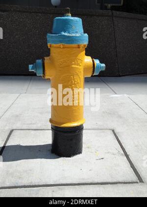 A Mueller fire hydrant, painted in festive colors, stands at the ready ...