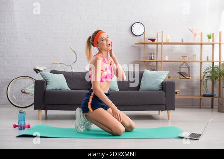 excited sportswoman looking at open palm isolated on yellow Stock Photo ...